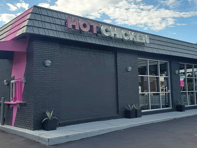 The neon "HOT CHICKEN" sign glows like a beacon of delicious promise against the sleek black exterior. Pink accents hint at the flavor explosion waiting inside.