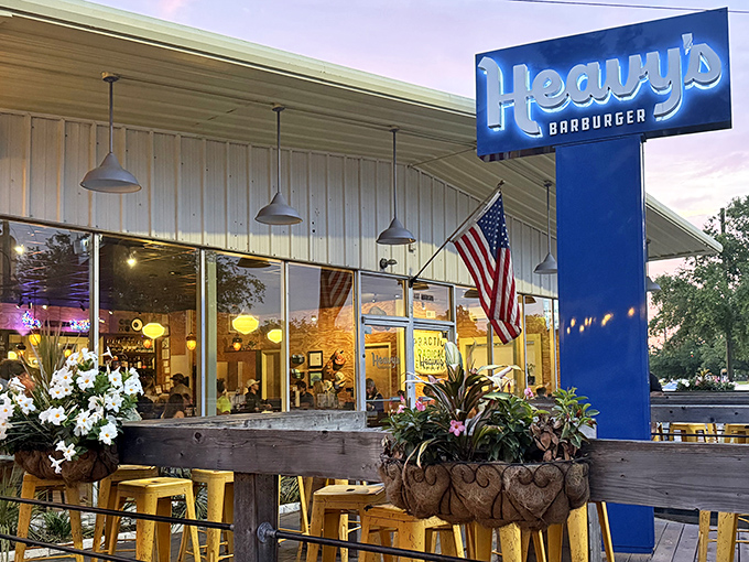 Heavy's iconic blue sign beckons burger enthusiasts like a neon North Star, promising comfort food paradise on Morrison Drive.