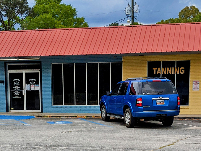 The unassuming blue exterior with its bright orange roof houses culinary treasures that locals drive miles to experience. Southern food paradise hiding in plain sight.