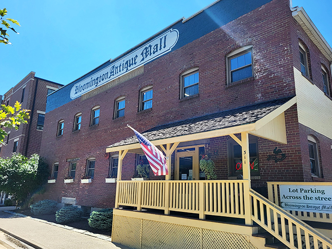 The brick facade of Bloomington Antique Mall welcomes treasure hunters with its cheerful yellow porch and American flag – like your grandmother's house, if she collected everything.