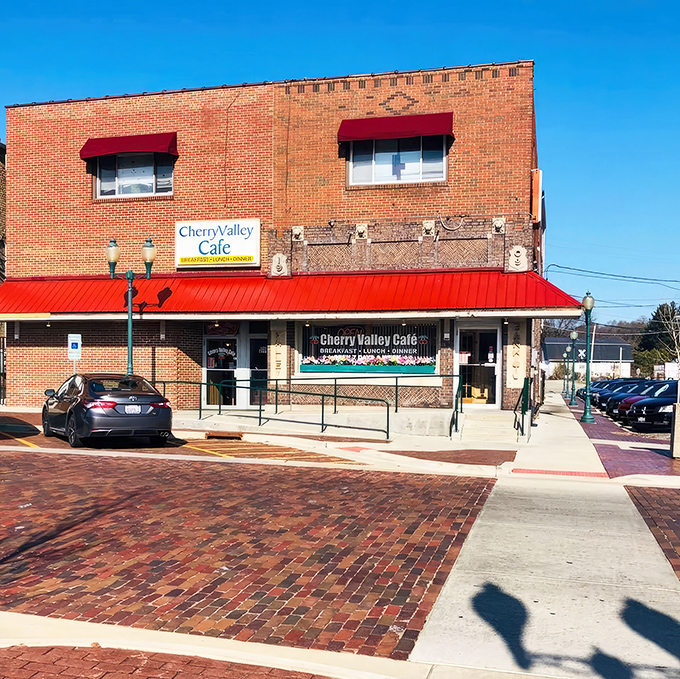 The brick facade and cherry-red awning of Cherry Valley Cafe stands as a beacon of breakfast hope on a quiet Illinois street.