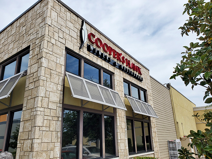 The stone facade of Cooper's Hawk stands like a wine country outpost that somehow landed in Orlando's tourist corridor. Napa Valley vibes in the Florida sunshine.
