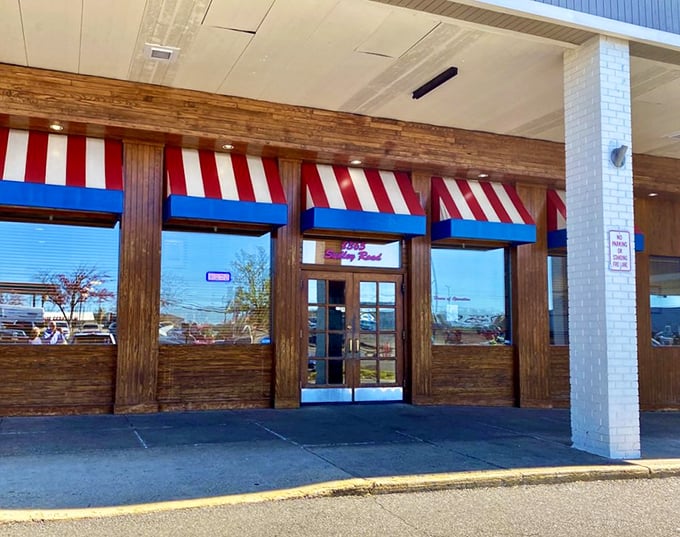 Those striped awnings practically salute you as you approach. The entrance promises a culinary journey through America's comfort food landscape.