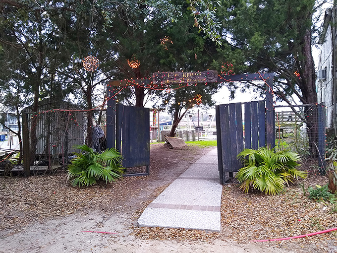 The entrance to culinary paradise isn't always grand &ndash; this weathered gate with twinkling lights promises the kind of authentic experience that fancy restaurants can only pretend to offer.