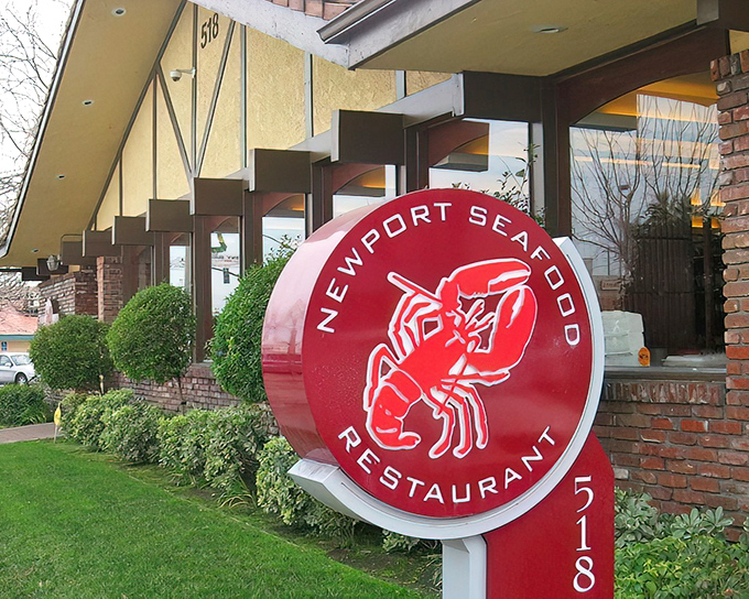 The unassuming brick exterior of Newport Seafood, marked by its simple signage, hides culinary treasures within &mdash; like discovering a Rolex in a paper bag.