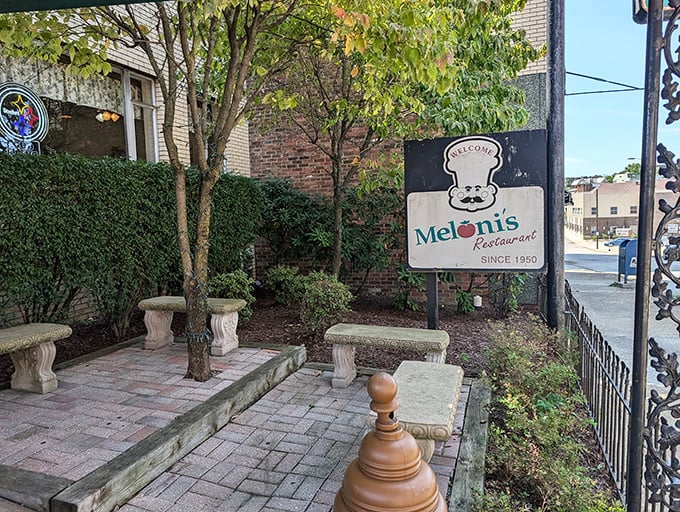 The charming courtyard entrance to Meloni's welcomes hungry pilgrims with stone benches and the iconic chef sign that's greeted diners for generations.