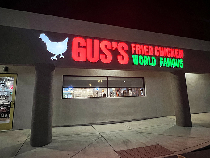 The unassuming exterior of Gus's hides a flavor paradise within. That red and green sign is basically a bat signal for fried chicken enthusiasts.