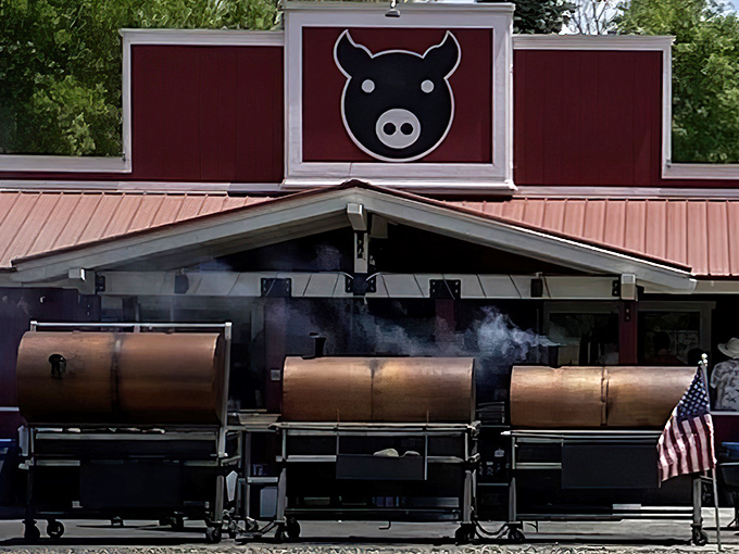 The iconic red building with its playful pig logo stands as a beacon of barbecue excellence, smoke wafting from those magnificent cylindrical smokers like a siren call to hungry travelers.