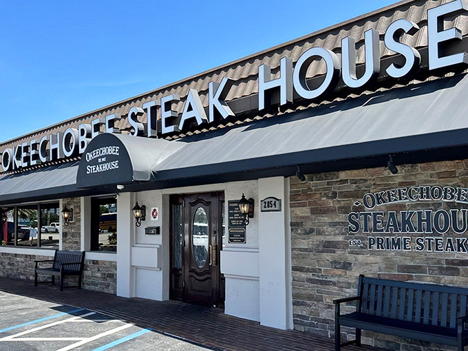 The unassuming exterior of Okeechobee Steak House belies the culinary treasures within. Like finding a diamond in a strip mall.