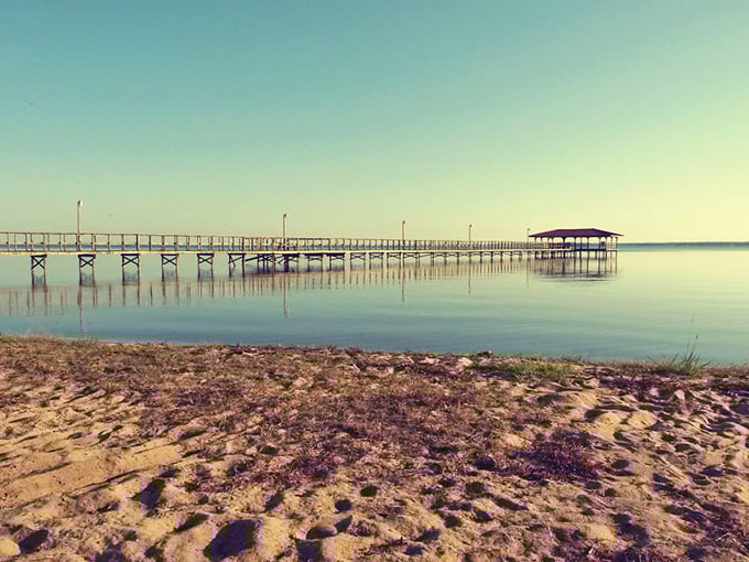The wooden pier stretches toward infinity, where sky meets water in that perfect North Carolina blue that no filter could improve upon.