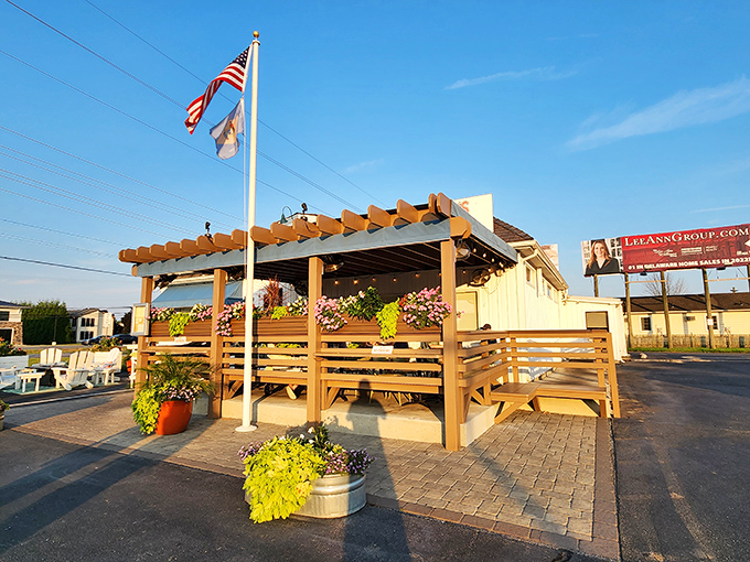 American flags flutter above the outdoor seating area, where wooden benches and vibrant planters create the perfect spot for savoring ocean treasures.