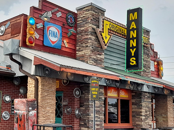 The neon sign at Manny's Original Chophouse glows like a beacon for hungry travelers, promising carnivorous delights behind that stone and brick facade.