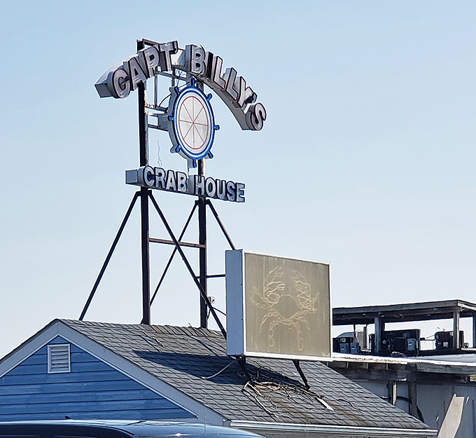 Captain Billy's iconic blue-roofed entrance beckons seafood lovers like a lighthouse for the hungry. The colorful crab mural hints at the treasures waiting inside.