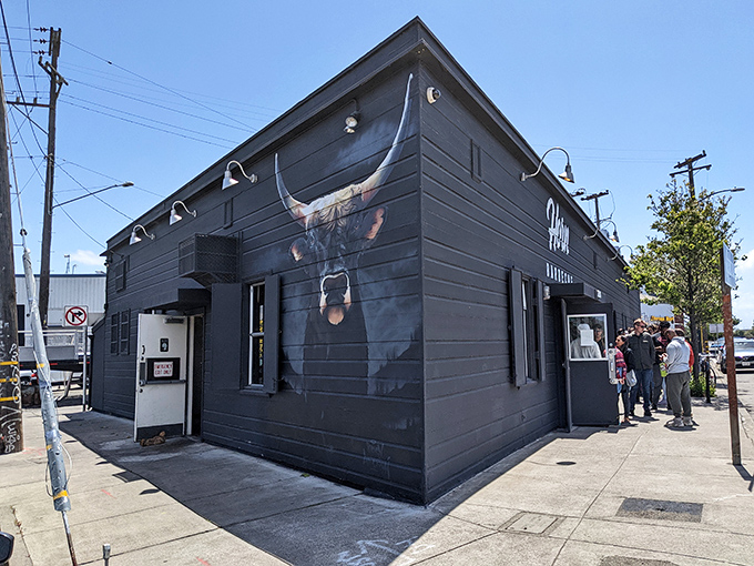 The black building with its bold bull mural stands like a smoke signal to barbecue pilgrims. This unassuming corner spot in Oakland houses meat magic worth the journey.