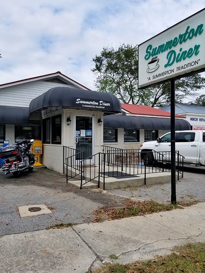 The unassuming white exterior with classic blue awnings promises what every great roadside discovery should: authenticity without pretension.