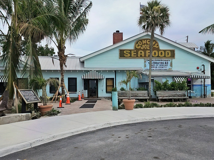 Old Florida charm meets Caribbean flair at Conchy Joe's, where palm trees stand guard and the promise of seafood treasures awaits behind that iconic sign.