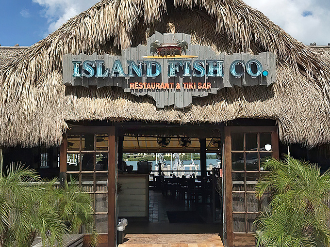 Sunlight dances through palm fronds as you approach this Marathon landmark, where fresh seafood and island vibes await just beyond those wooden doors.