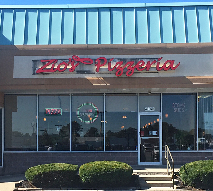 The neon glow of Zio's Pizzeria sign beckons like a lighthouse for the hungry. Pizza paradise awaits behind those doors.