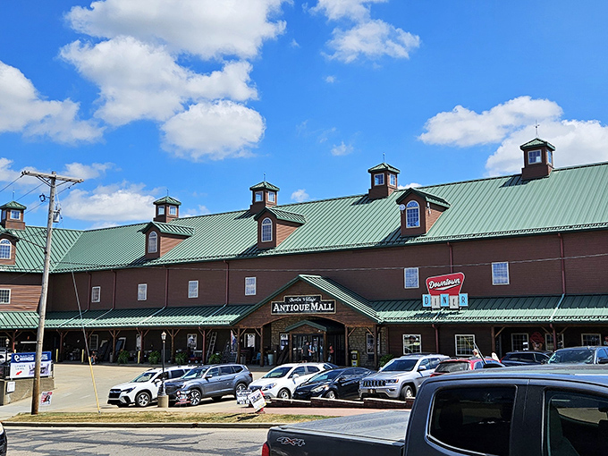 The barn-like exterior of Berlin Village Antique Mall stands proudly against an Ohio blue sky, its distinctive green roof and cupolas beckoning treasure hunters from miles around. 