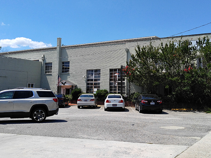 The unassuming exterior of Old Mill Antique Mall stands like a vault of treasures waiting to be discovered, with its American flag proudly waving hello to bargain hunters.