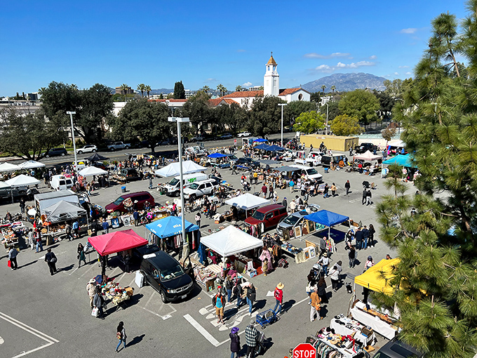 Aerial view of treasure hunters navigating a sea of canopies and tables, with the iconic Pasadena architecture creating the perfect backdrop for bargain quests.