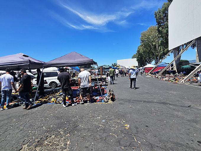 A sea of colorful canopies stretches across the asphalt landscape, where treasure hunters navigate between parked cars and pop-up shops under perfect California skies.