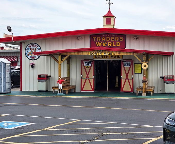 The iconic red-roofed entrance to Traders World beckons treasure hunters with its barn-inspired architecture and promise of discoveries waiting just beyond those doors.