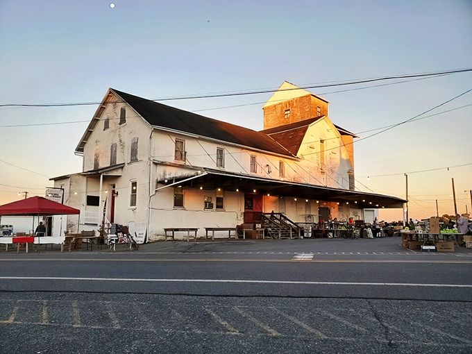 The historic mill building glows in sunset light, its weathered white exterior a beacon for treasure hunters seeking Pennsylvania's best-kept bargain secret.