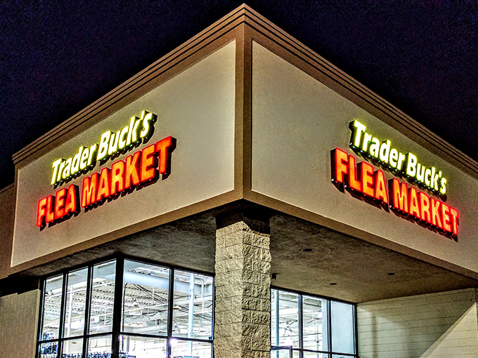 The neon glow of Trader Buck's sign is like a lighthouse for bargain hunters, beckoning with promises of treasures waiting to be discovered inside.