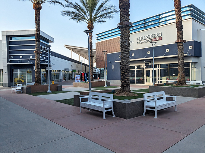 Palm trees stand sentinel over stylish seating areas, offering shoppers a moment of desert oasis calm before the next bargain-hunting storm.