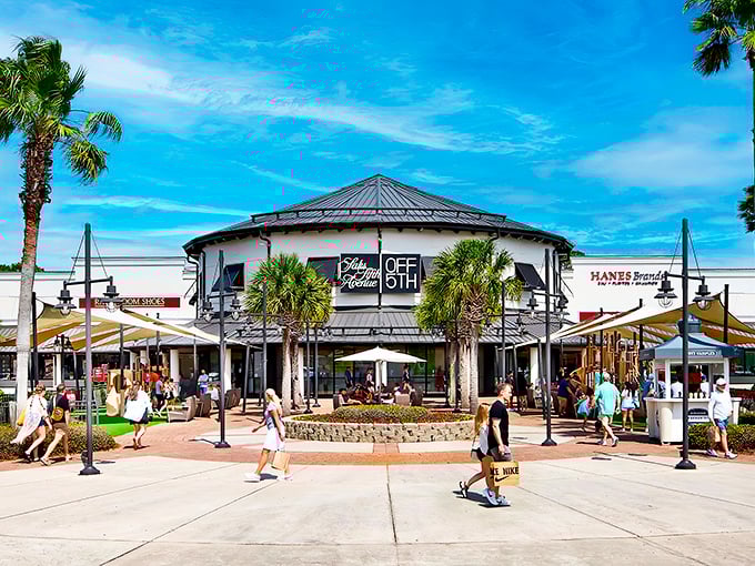 The iconic yellow rotunda of Saks OFF 5TH stands like a retail lighthouse, guiding bargain hunters to the shores of discounted luxury.