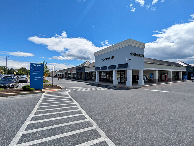 The retail promised land awaits! Tanger Outlets Hershey's pristine exterior gleams under Pennsylvania blue skies, beckoning shoppers with the siren call of savings.