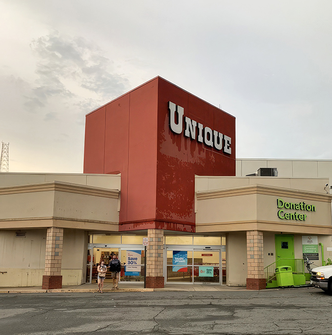 The iconic red facade of Unique beckons bargain hunters like a retail lighthouse guiding ships to treasure-filled shores.
