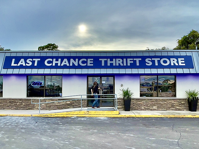 The iconic blue signage of Last Chance Thrift Store stands out against Florida's moody sky, promising treasure hunters a day of discoveries within.