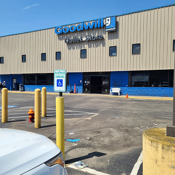 The blue-trimmed facade of Goodwill's Outlet Store stands like a treasure chest waiting to be unlocked, promising adventures in bargain hunting beyond those automatic doors.