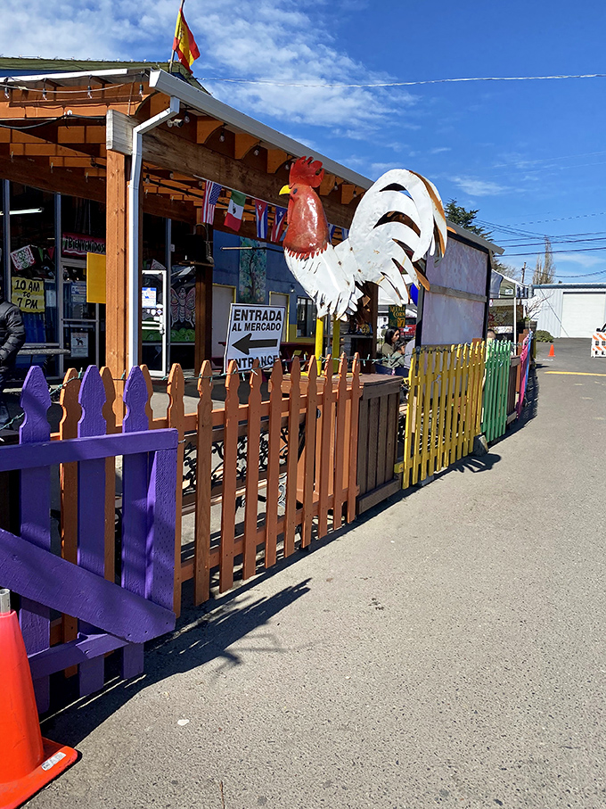 Colorful fences and a proud rooster statue welcome visitors to M&M Marketplace's outdoor vendor area, where weekend treasures await.
