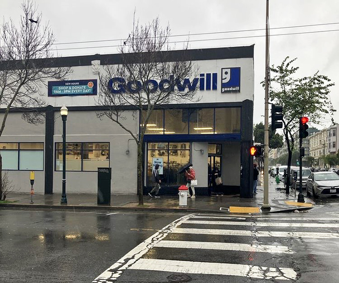 The blue Goodwill sign beckons like a lighthouse for bargain hunters, even on rainy San Francisco days when treasure hunting feels especially rewarding.