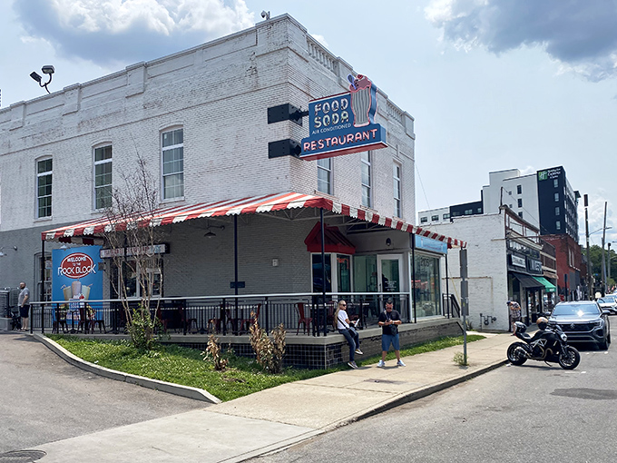 The iconic red and white striped awning of Elliston Place Soda Shop beckons like a time machine disguised as a restaurant in Nashville's Rock Block.