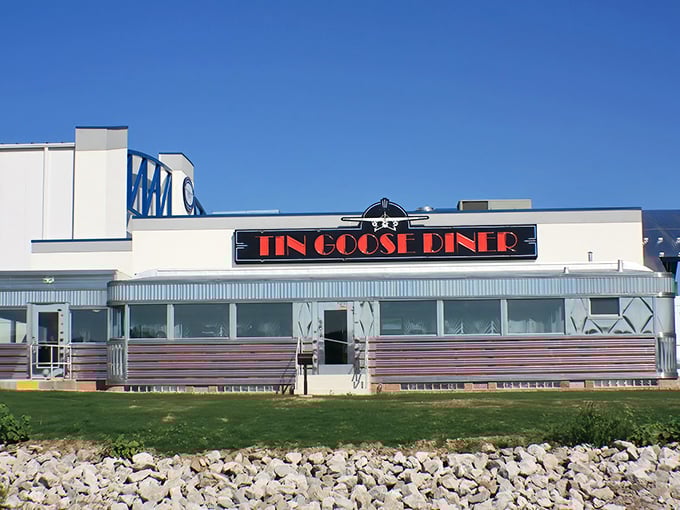 The gleaming stainless steel exterior of Tin Goose Diner shines like a beacon for hungry travelers, promising retro charm and comfort food worth the journey.