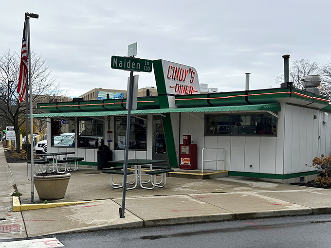 The iconic green-trimmed exterior of Cindy's Diner stands as a beacon of hope for hungry travelers. Fifteen seats of pure culinary magic await inside.