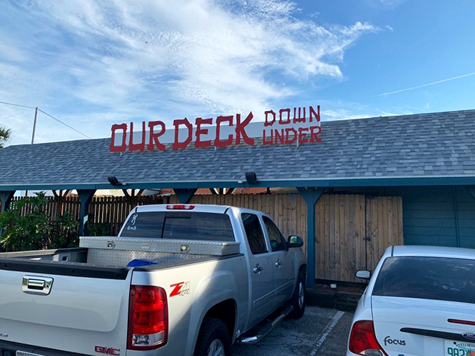 The bright red lettering against turquoise blue isn't just a sign&mdash;it's a promise of Florida seafood magic waiting beneath the Dunlawton Bridge.