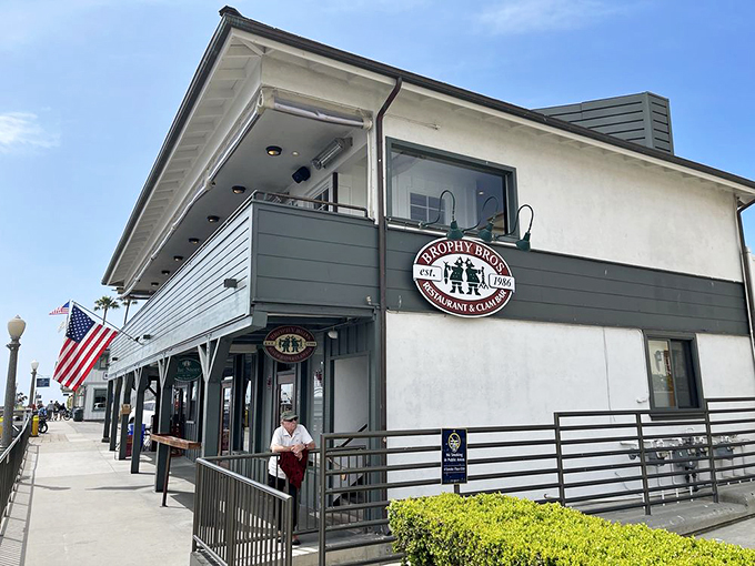 The no-frills exterior waves a hearty welcome at Brophy Bros., where that iconic circular sign promises seafood treasures within those weathered blue-gray walls.