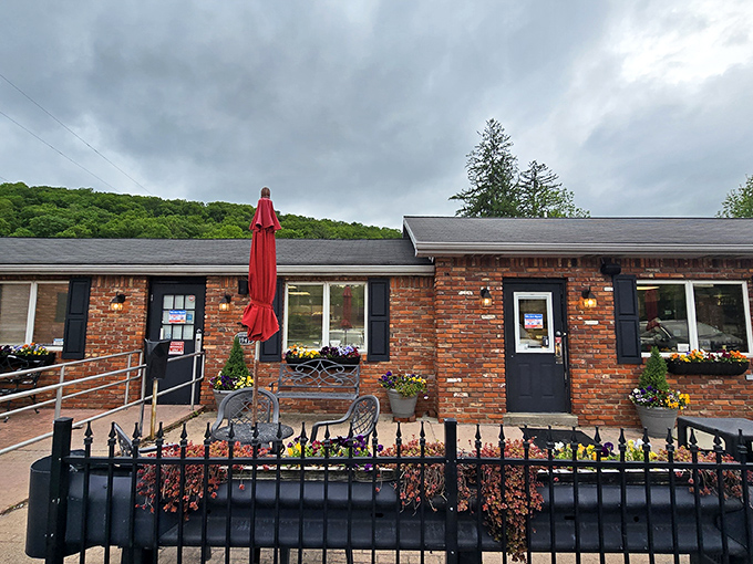 The humble brick exterior of The Pie Shoppe, with its cheerful red umbrellas, promises comfort food paradise hiding in plain sight.