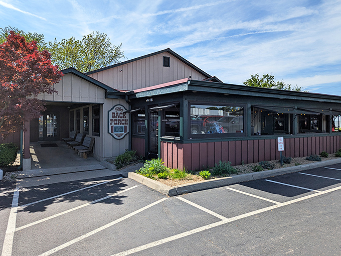 The unassuming exterior of Back Porch Saloon beckons like an old friend, promising comfort food treasures within its rustic wooden walls.