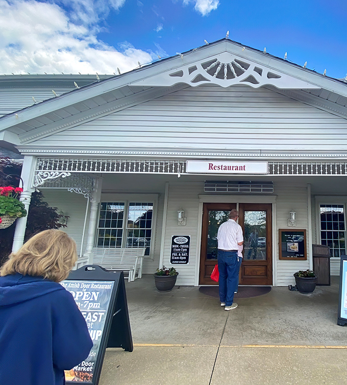 The classic white farmhouse exterior of Amish Door Restaurant stands like a beacon of comfort food against Ohio's big sky&mdash;promising delicious rewards for those who make the journey. 
