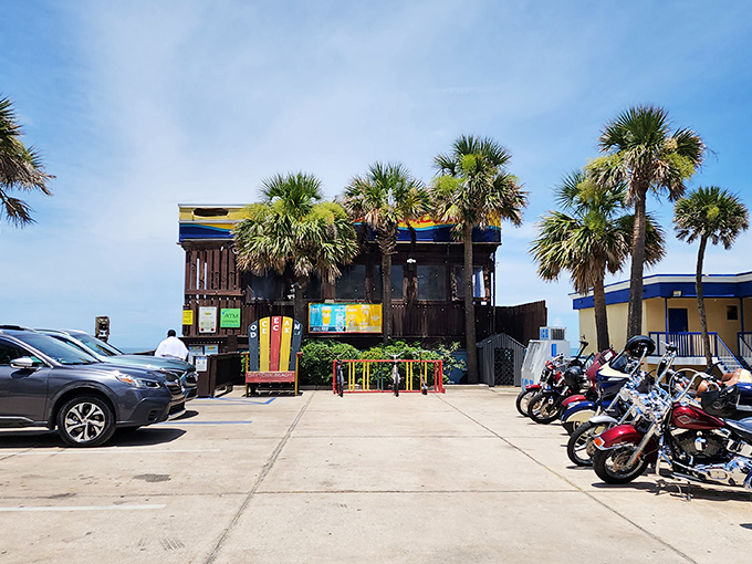 The colorful exterior of Ocean Deck beckons like a tropical mirage, palm trees swaying as if they're dancing to the reggae soundtrack inside.