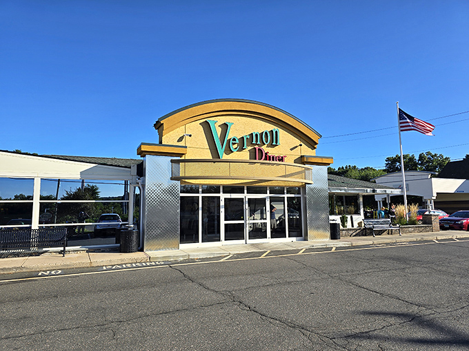 The iconic curved facade of Vernon Diner stands proudly against Connecticut's blue sky, like a beacon of breakfast hope for hungry travelers.