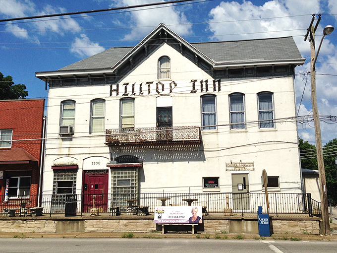 The stately white facade of Hilltop Inn stands proudly against an Indiana sky, a culinary time capsule waiting to share its delicious secrets.