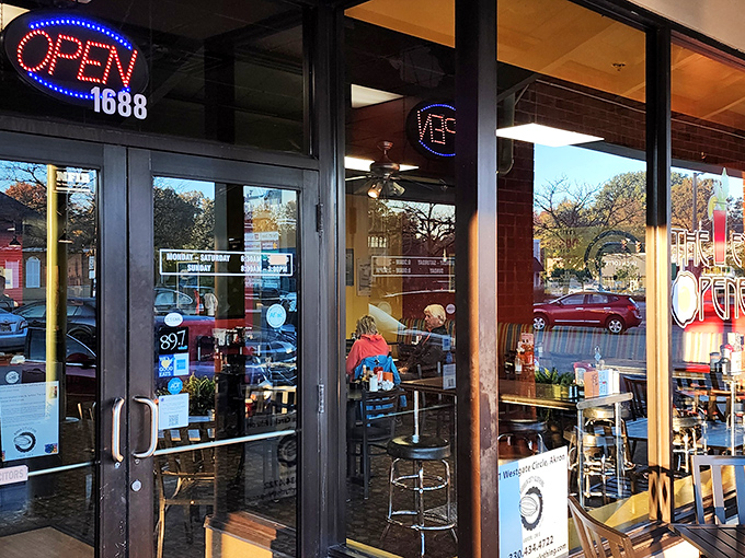 The welcoming storefront of The Eye Opener beckons with its distinctive sign and cozy patio seating&mdash;breakfast paradise awaits behind those doors.