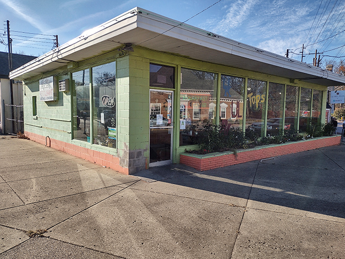 Daylight reveals the charming mint-green exterior, a mid-century time capsule standing proudly at its Highlands corner like it owns the place.